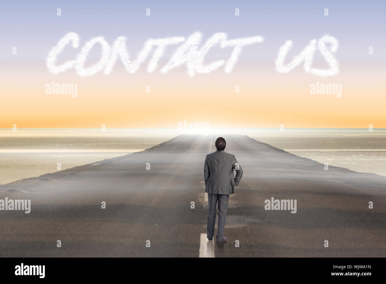 The word contact us and businessman with hand on hip against road ...