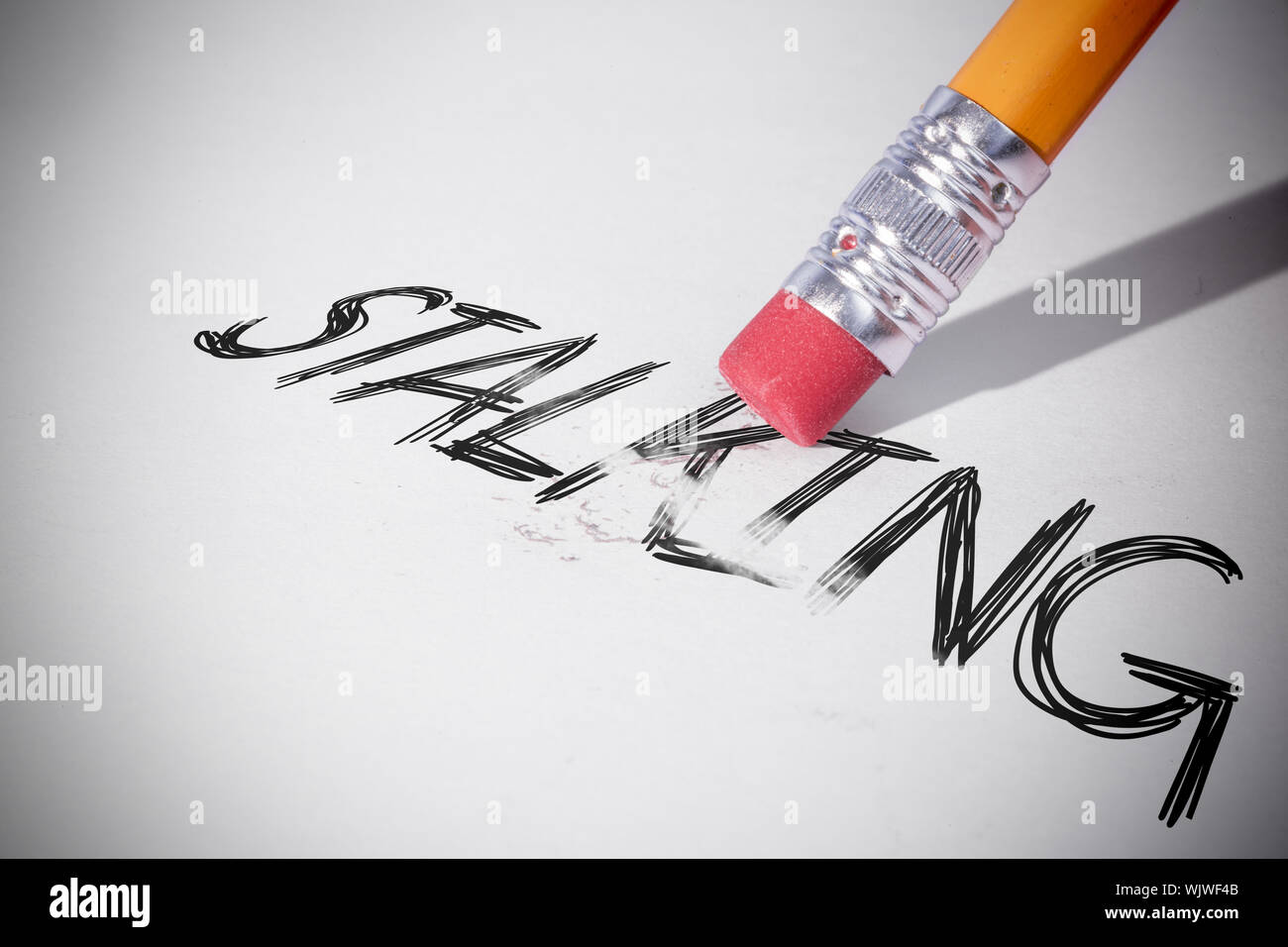 Pencil erasing the word stalking on paper Stock Photo - Alamy