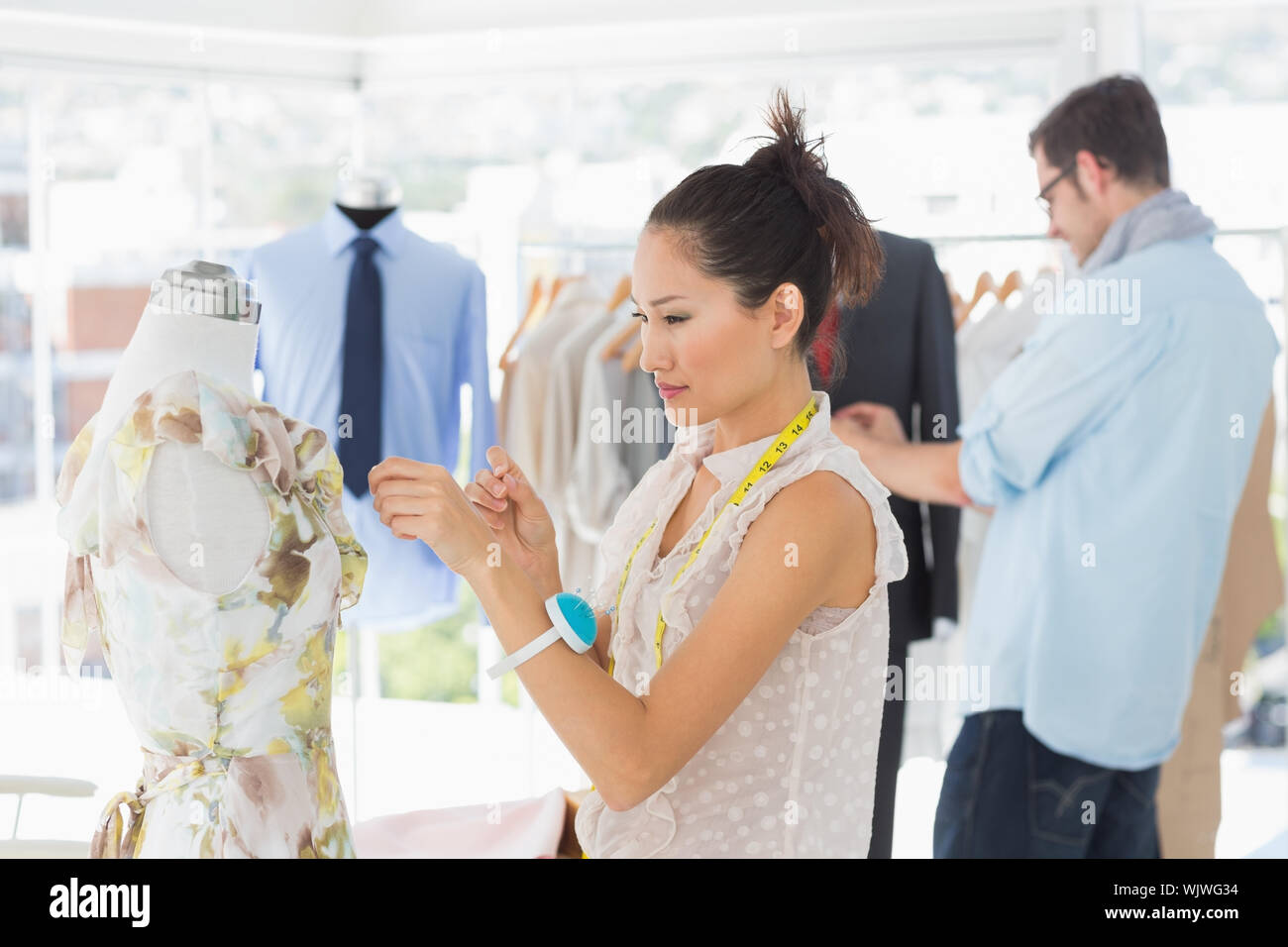 Male and female fashion designers at work in a bright studio Stock ...