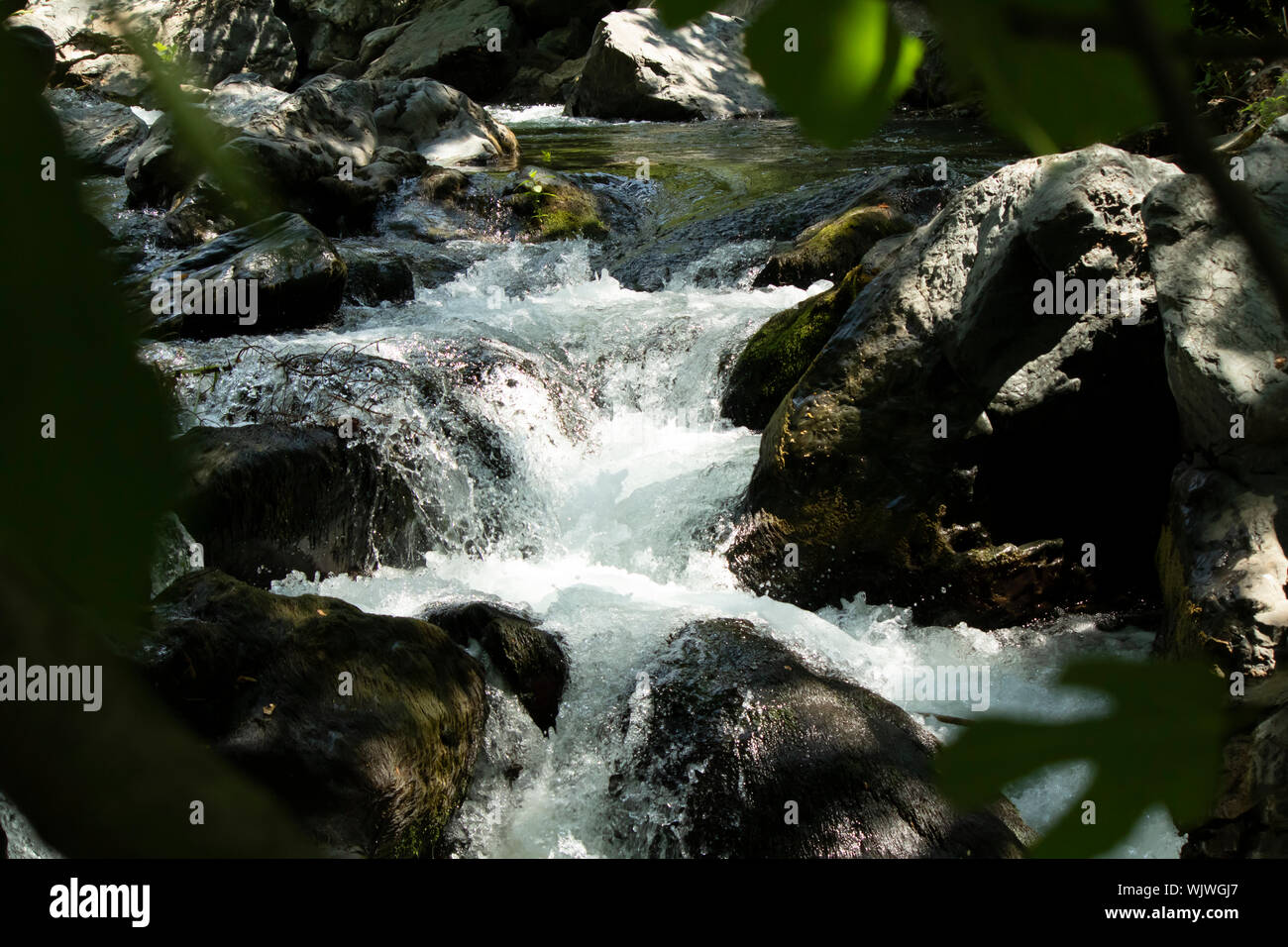 Clean water flowing between cliffs Stock Photo - Alamy