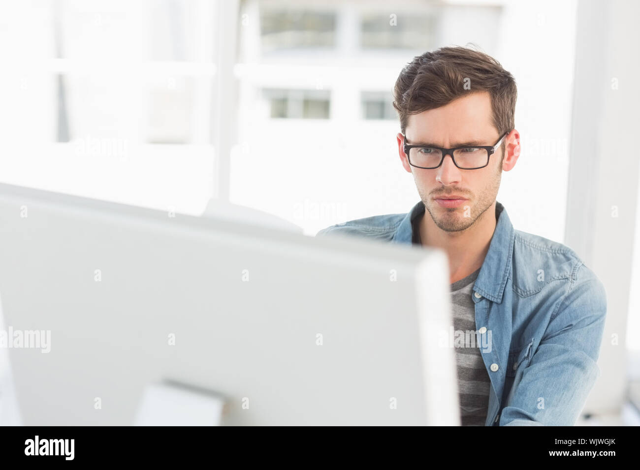 Concentrated young male artist using computer in the office Stock Photo ...