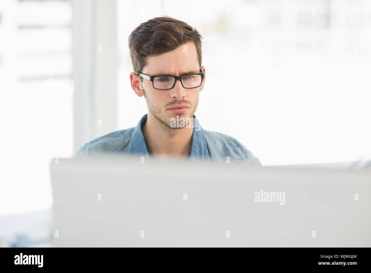 Concentrated young male artist using computer in the office Stock Photo ...