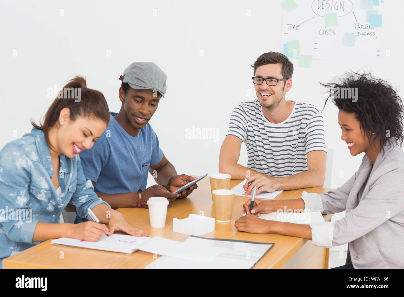 Group of happy artists in discussion at desk at the office Stock Photo ...