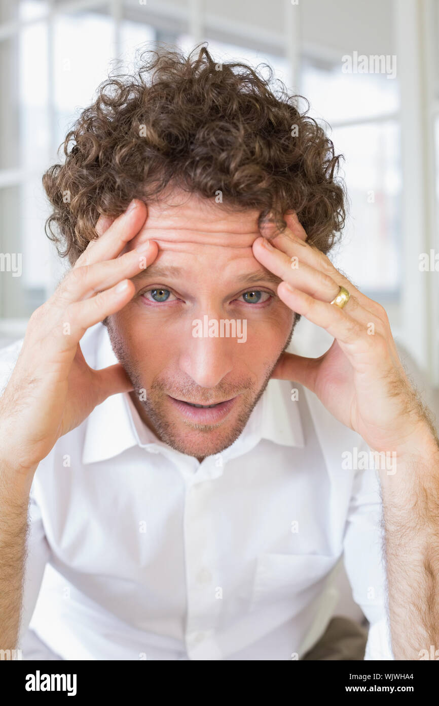 Portrait of a worried well dressed man sitting with head in hands on ...