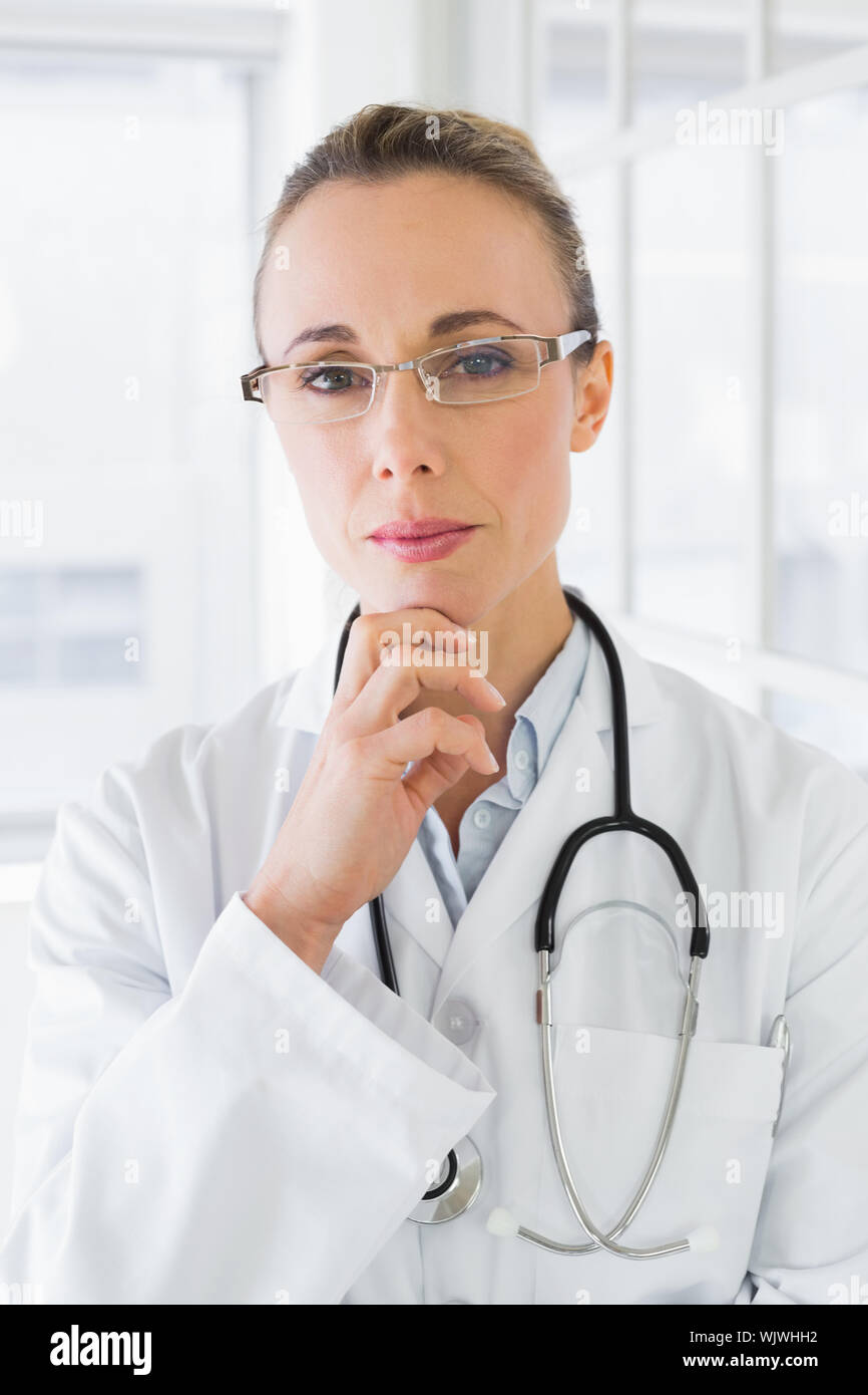 Portrait of a serious beautiful female doctor standing in the hospital ...