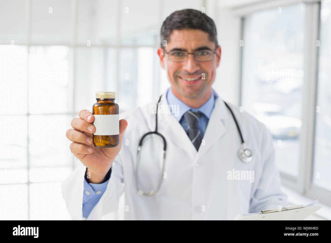 Smiling male doctor showing pills hi-res stock photography and images ...