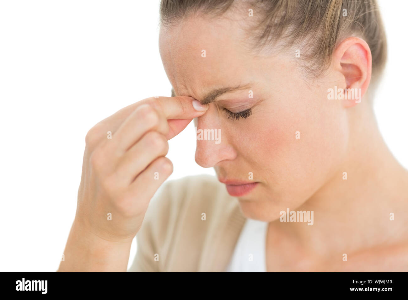 Woman with headache pinching her nose on white background Stock Photo ...