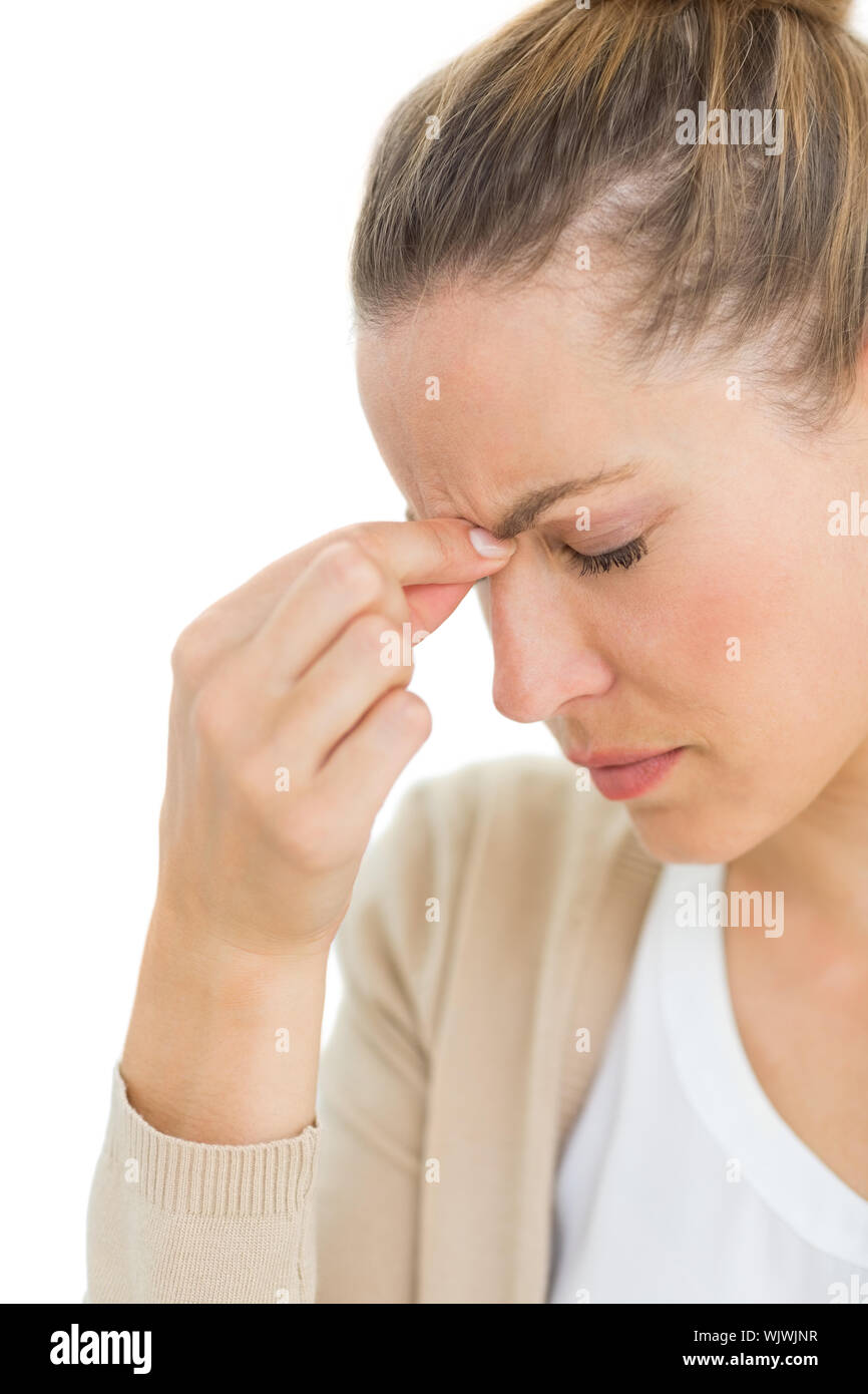 Woman with headache pinching her nose and wincing on white background ...