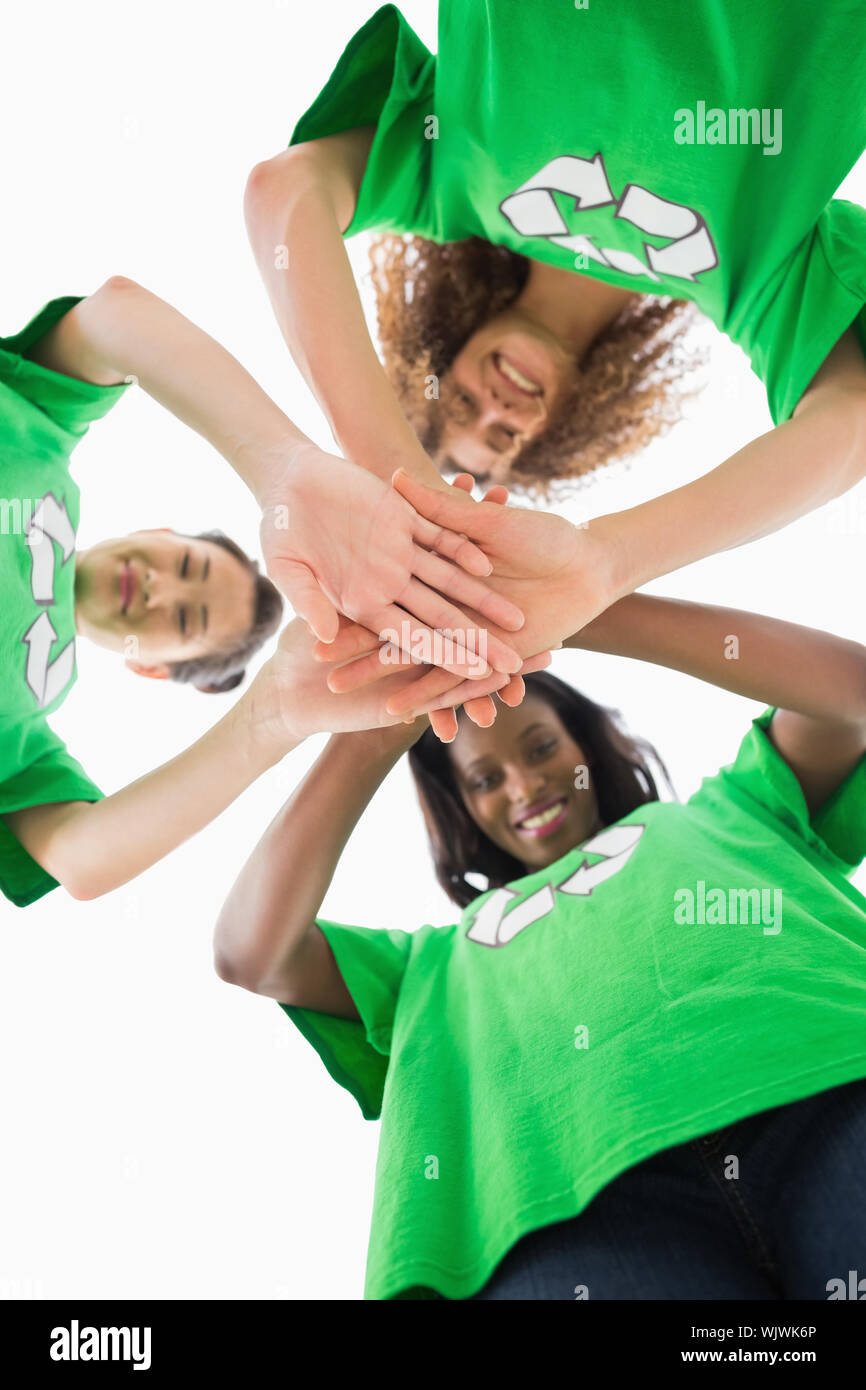 Environmental activists putting hands together smiling down at camera ...