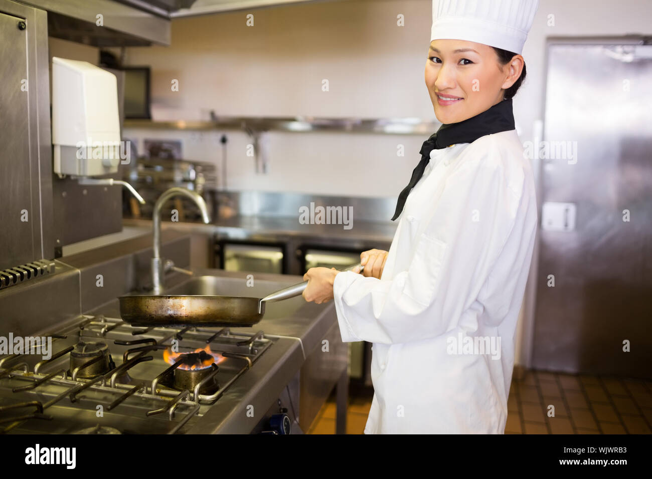 Side view portrait of a female cook preparing food in the kitchen Stock ...