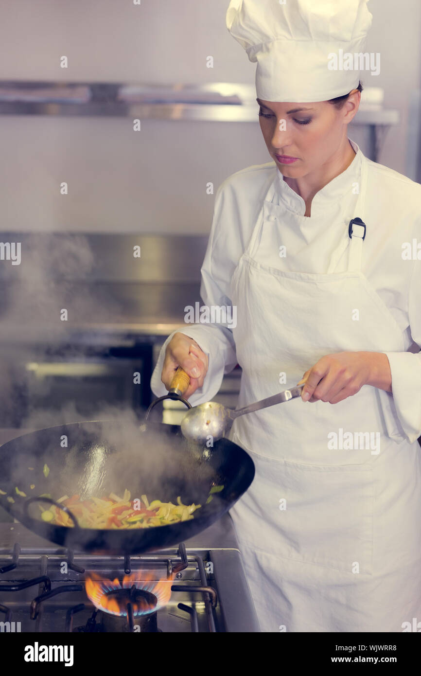 Concentrated female chef preparing food in the kitchen Stock Photo - Alamy