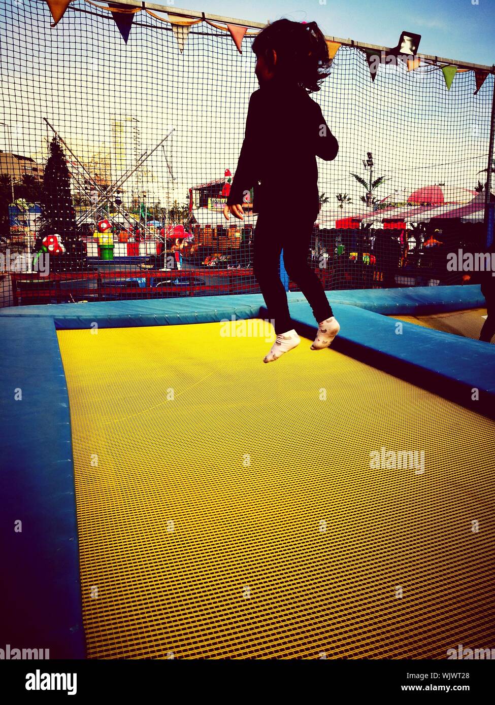 Girl jumping on trampoline outdoors hi-res stock photography and images ...