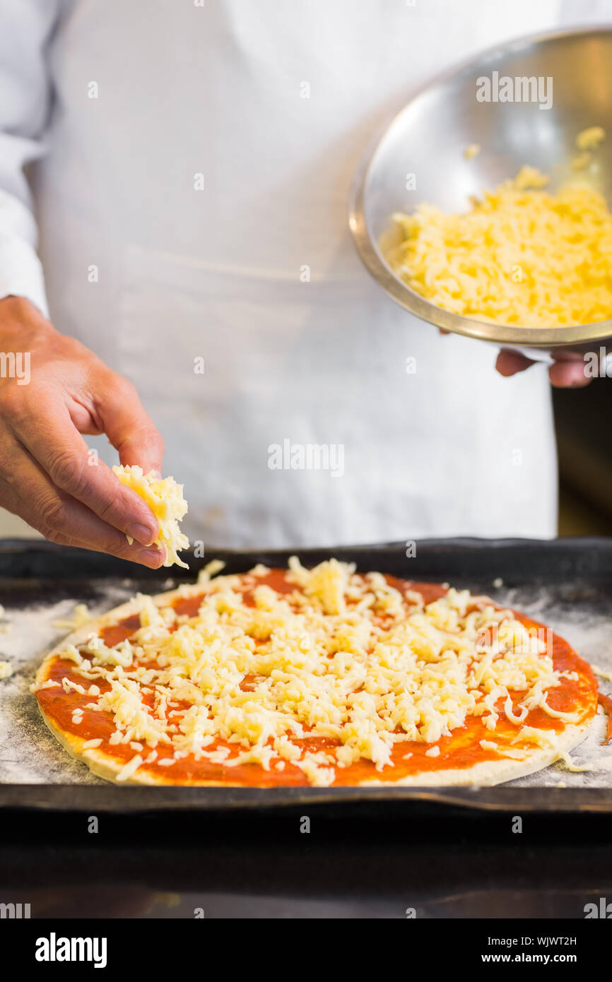 Closeup mid section of a male chef preparing pizza in kitchen Stock ...