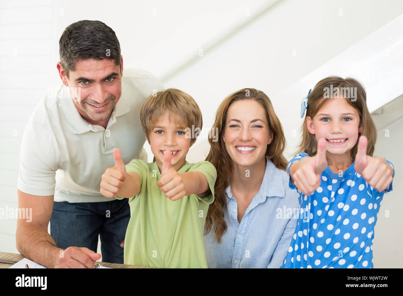 Portrait of happy family showing thumbs up at home Stock Photo - Alamy