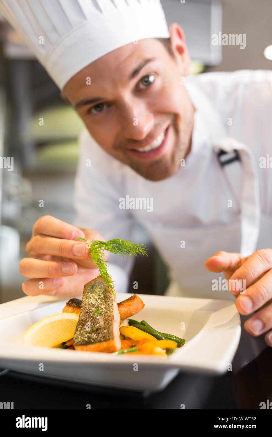 Closeup of a smiling male chef garnishing food in the kitchen Stock ...