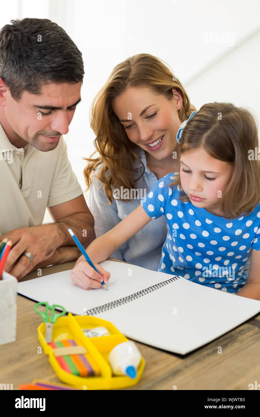 Parents assisting daughter in coloring at home Stock Photo - Alamy