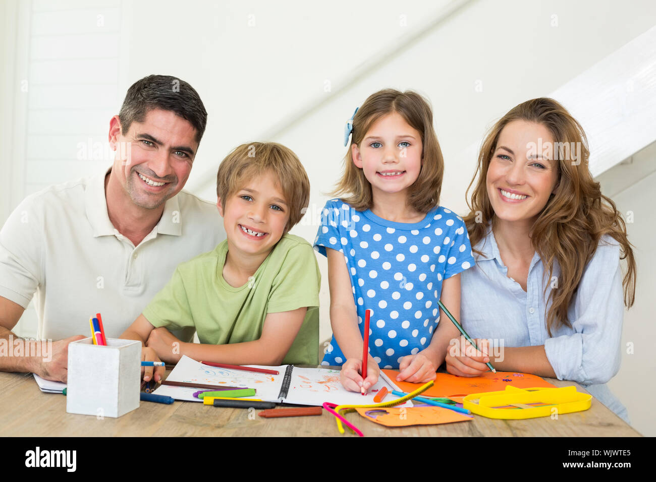 Portrait of happy family drawing together at table Stock Photo - Alamy