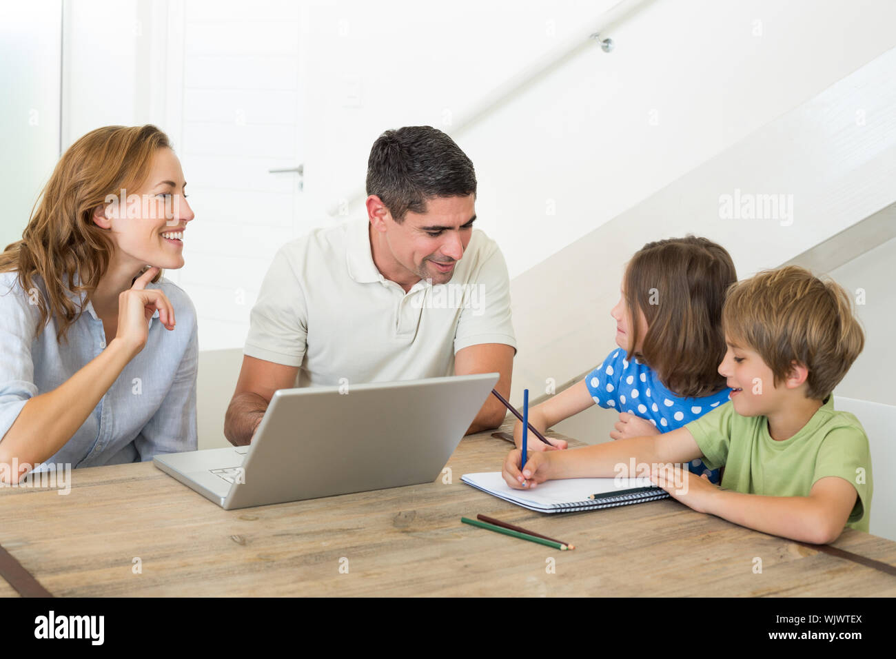 Parents assisting daughter in coloring at home Stock Photo - Alamy