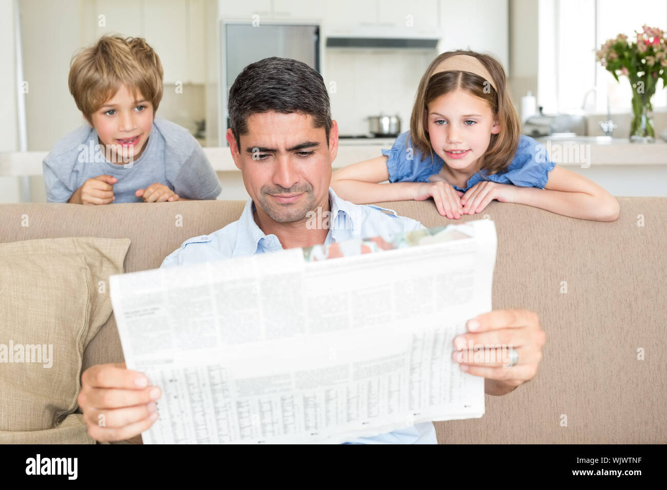 Father and cute children reading newspaper at home Stock Photo - Alamy