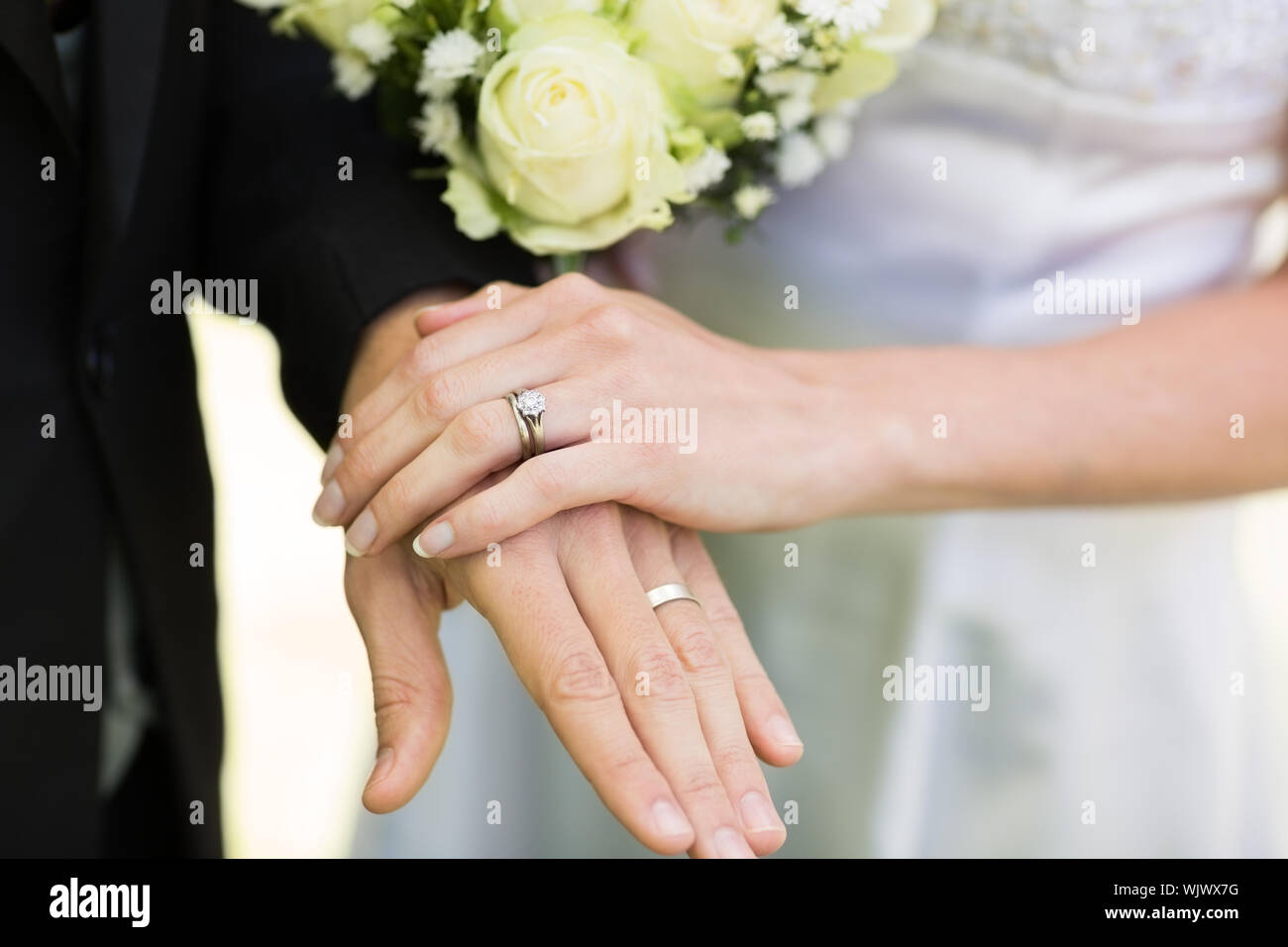 Closeup of bride and groom showing wedding rings touching hands Stock ...