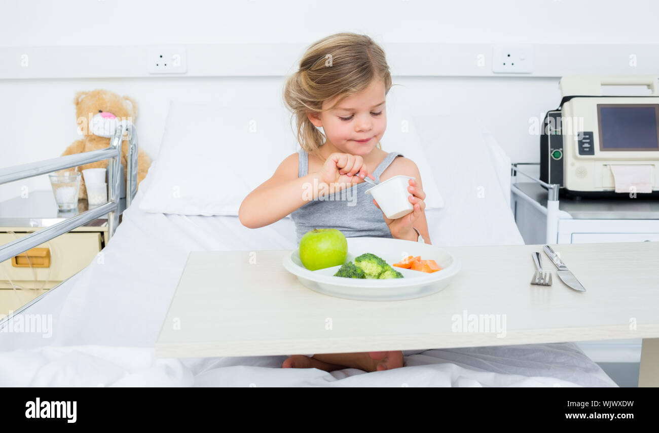 Portrait of little sick girl eating healthy food in hospital bed Stock ...