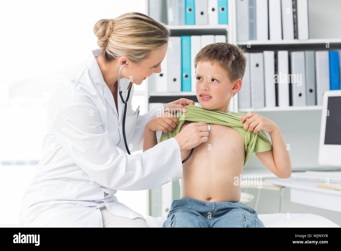 Female doctor examining boy with stethoscope in clinic Stock Photo - Alamy