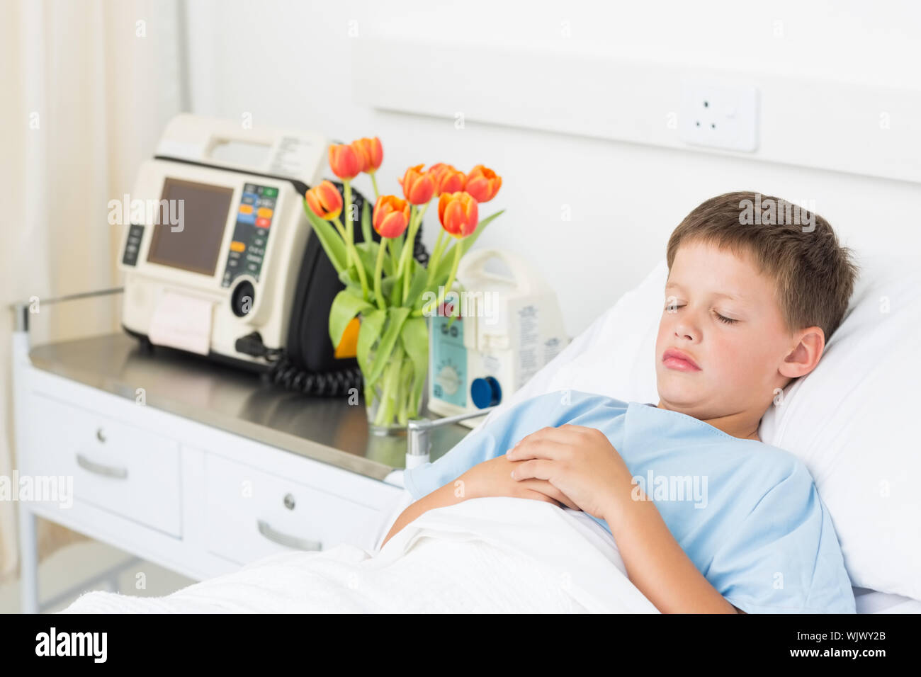 Sick little boy resting in hospital bed Stock Photo - Alamy
