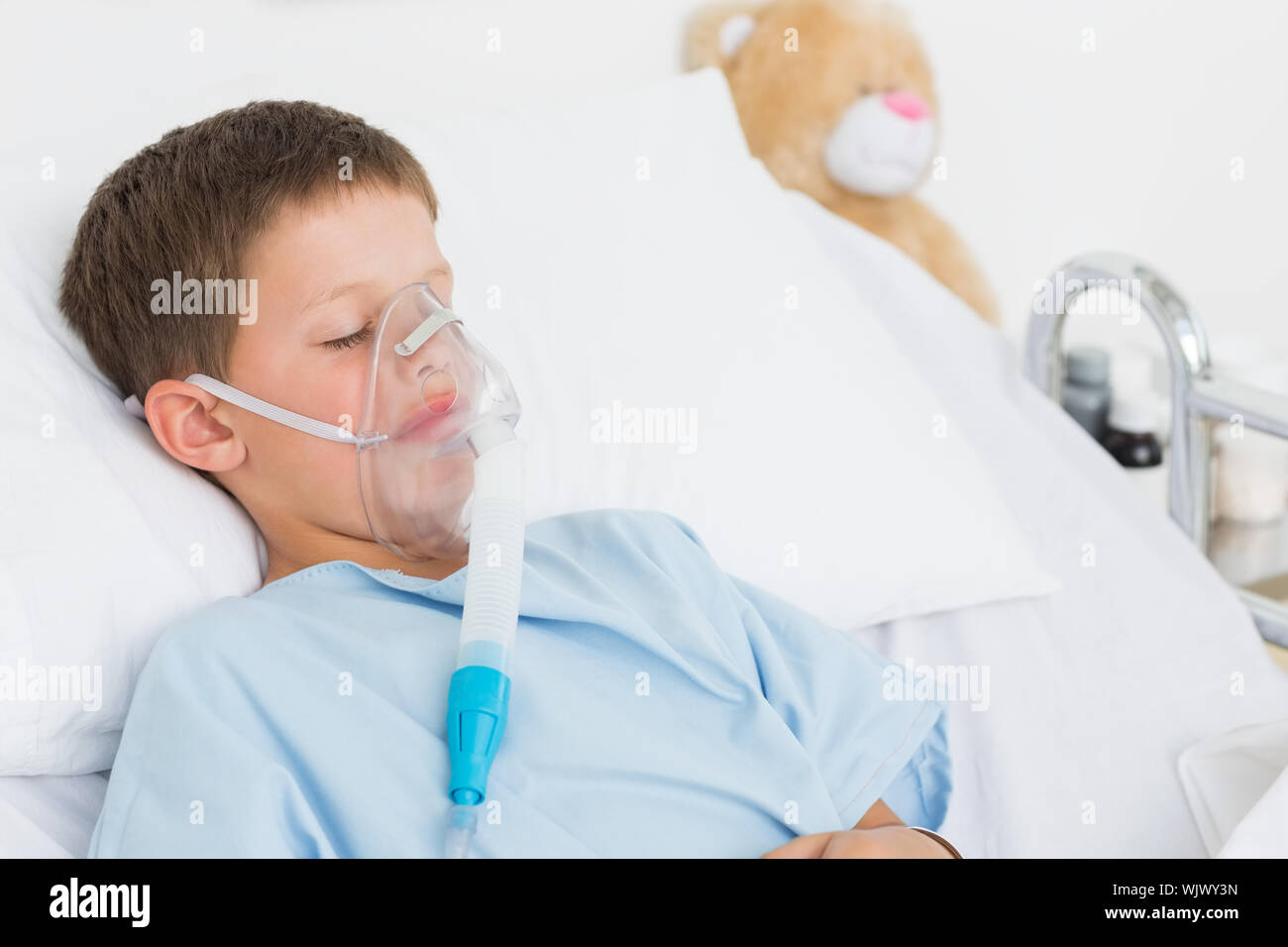 Sick little boy with oxygen mask in hospital bed Stock Photo - Alamy