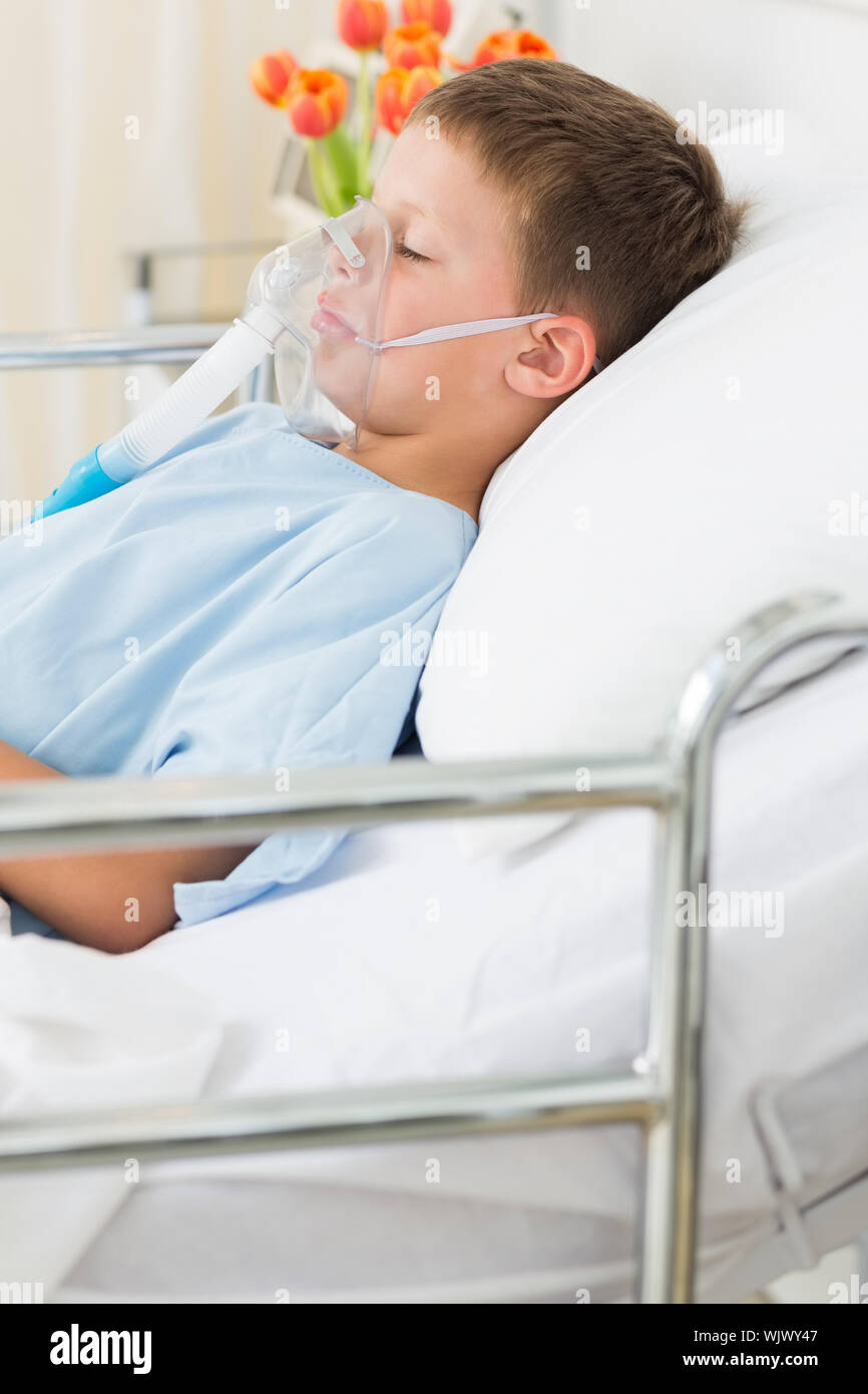 Side view of sick boy wearing oxygen mask in hospital bed Stock Photo ...