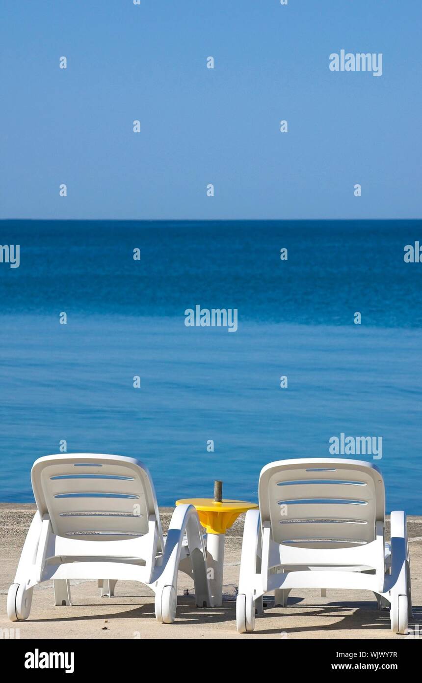 Two plastic chairs at the edge of a sea Stock Photo - Alamy