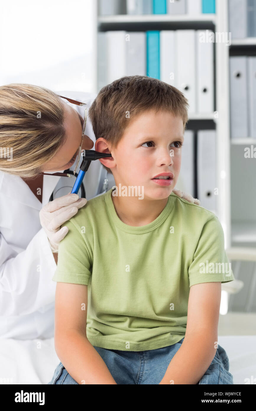 Little boy being examined by female doctor with otoscope in clinic ...