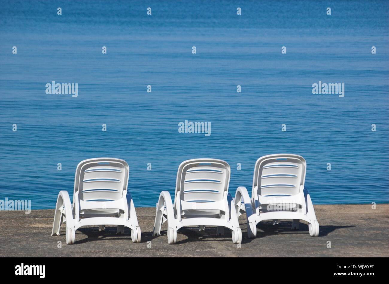 Plastic beach chair at the edge of a sea Stock Photo - Alamy