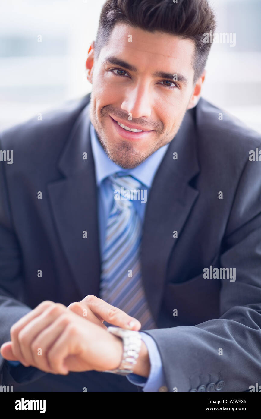 Businessman sitting checking watch smiling hi-res stock photography and ...