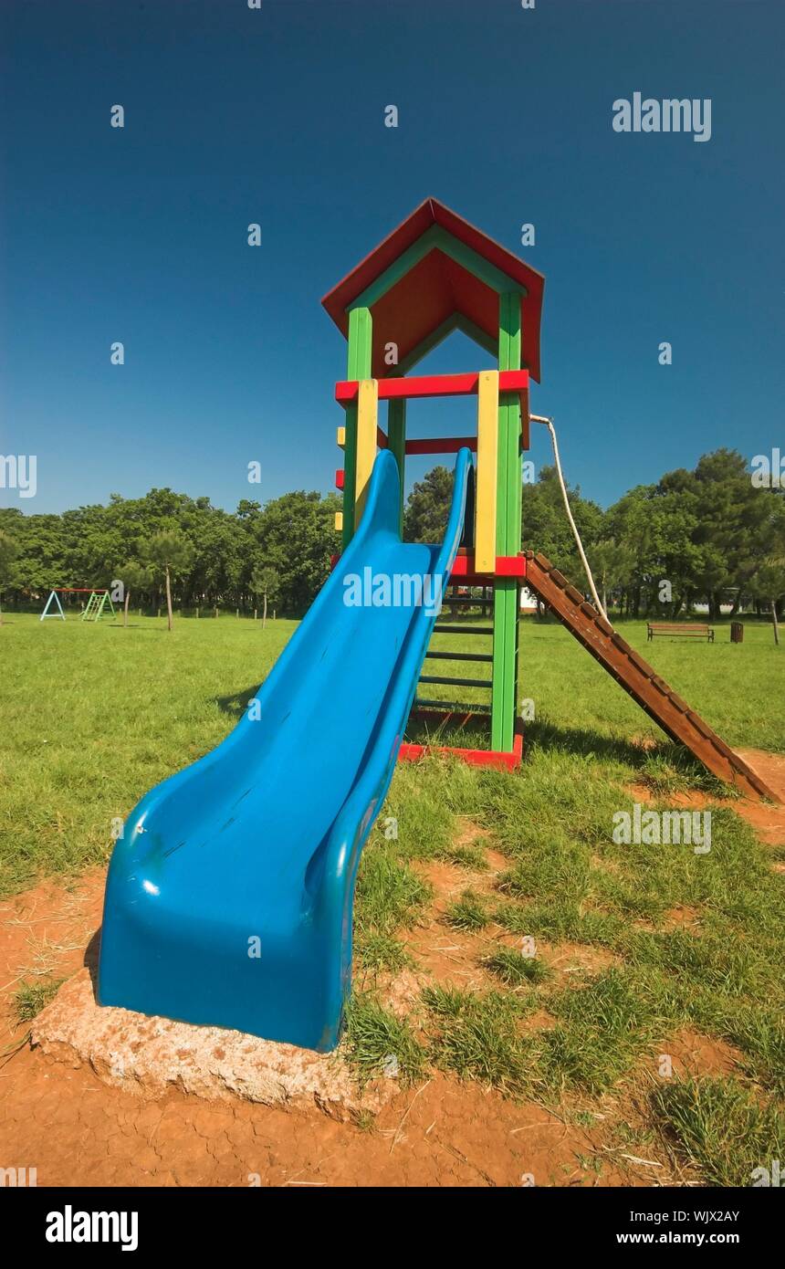 Blue slide at a children's playground in summer Stock Photo - Alamy