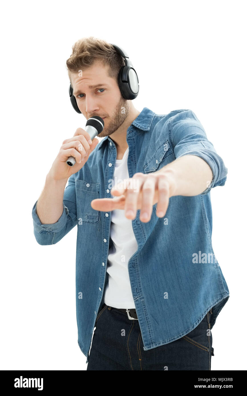 Portrait of a young man singing into microphone over white background Stock Photo - Alamy
