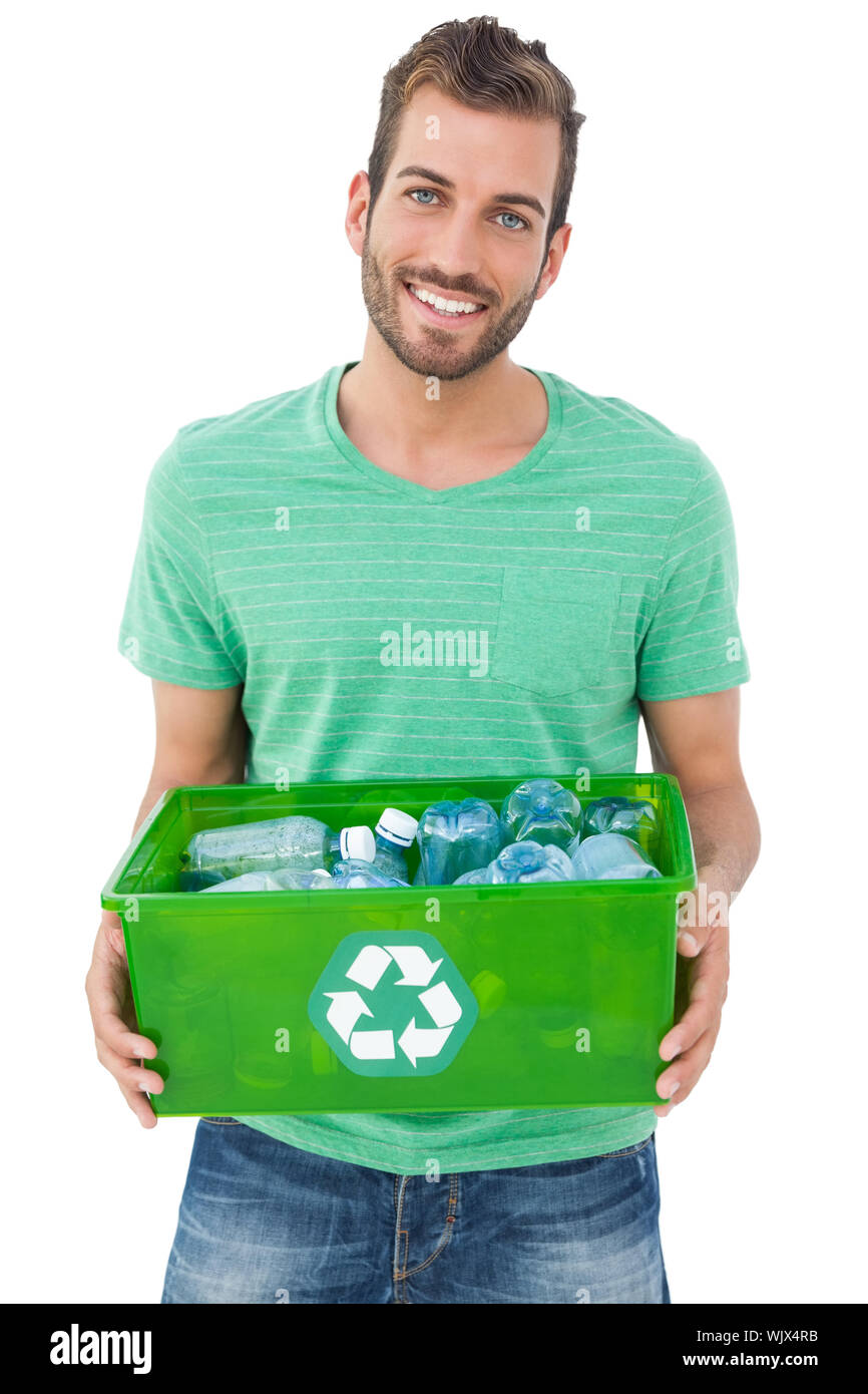 Portrait of a smiling young man carrying recycle container over white ...