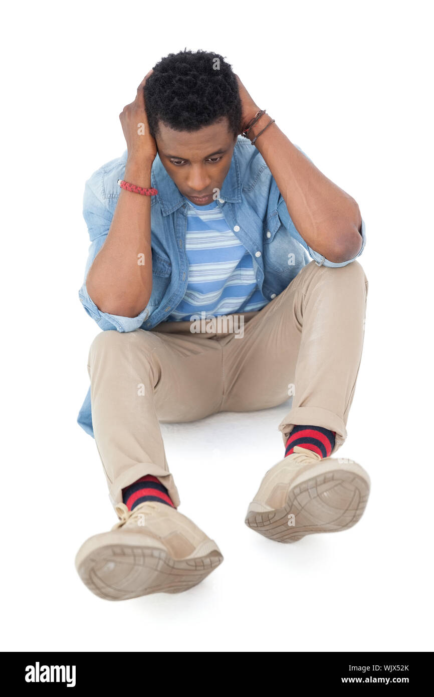 Full length of a thoughtful young man sitting over white background ...