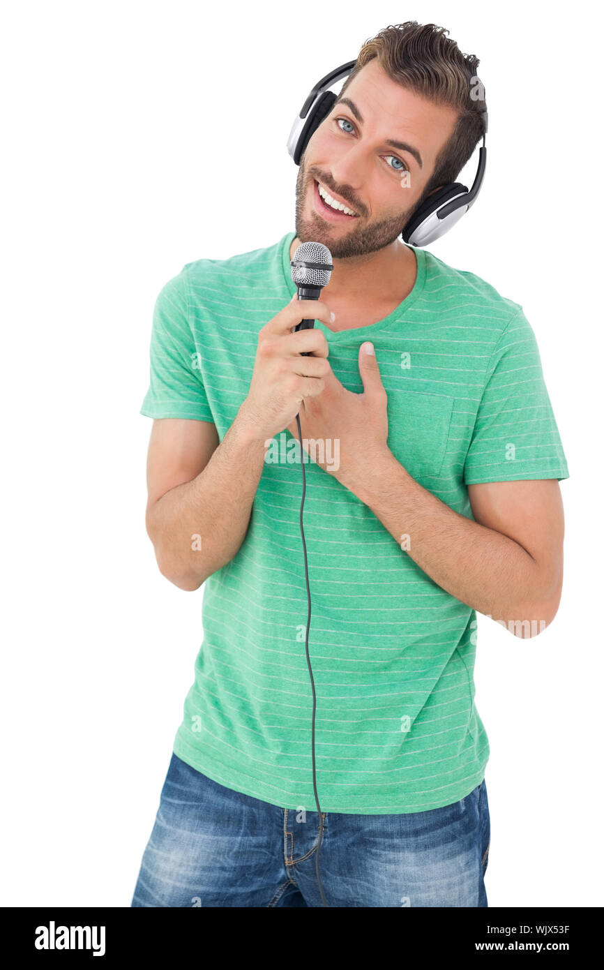 Portrait of a young man singing into microphone over white background Stock Photo - Alamy