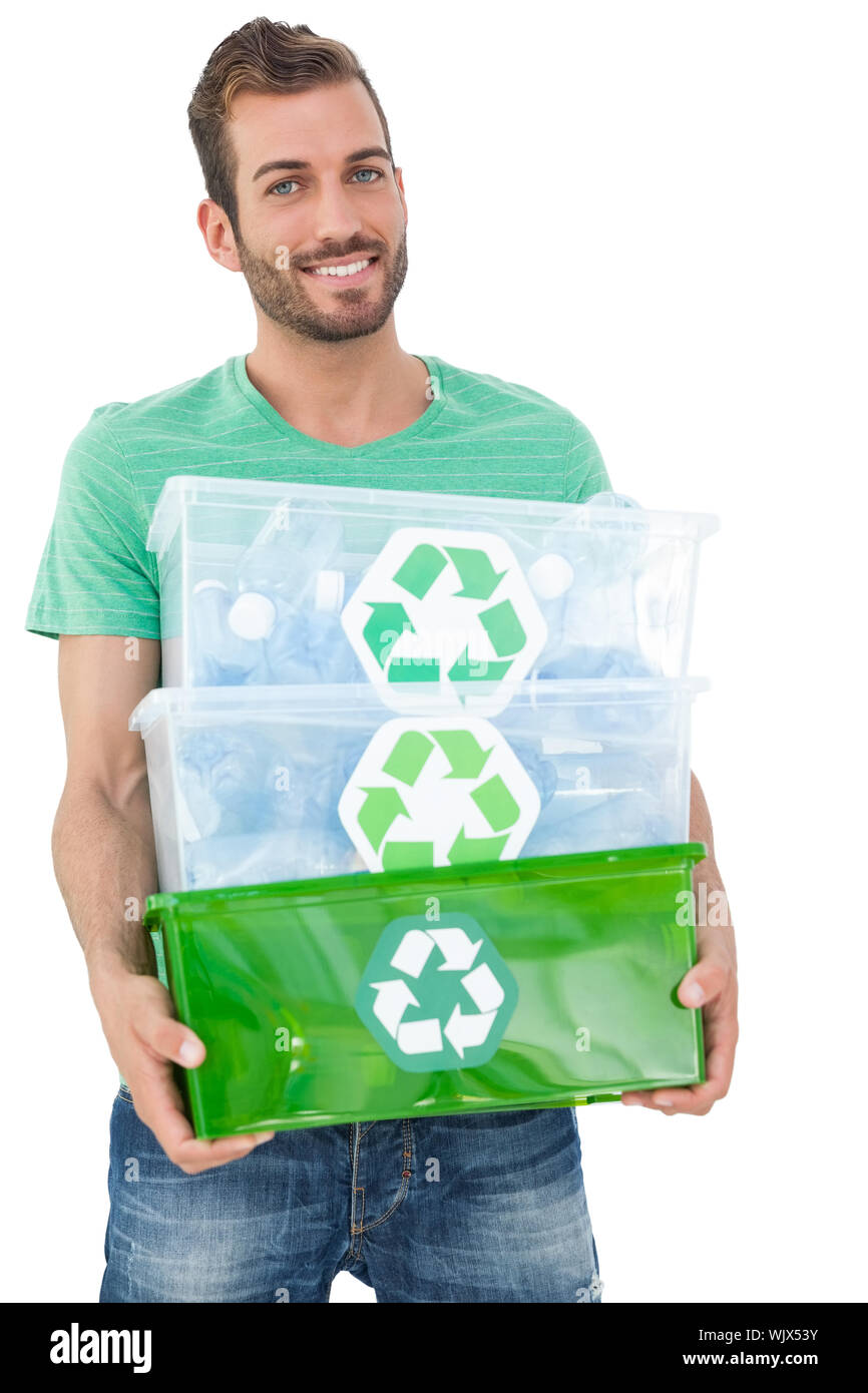 Portrait of a smiling young man carrying recycle containers over white ...