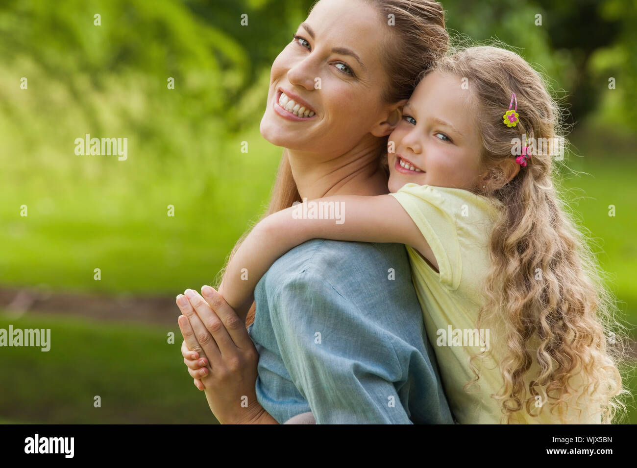 Side view portrait of a woman carrying young girl at the park Stock ...