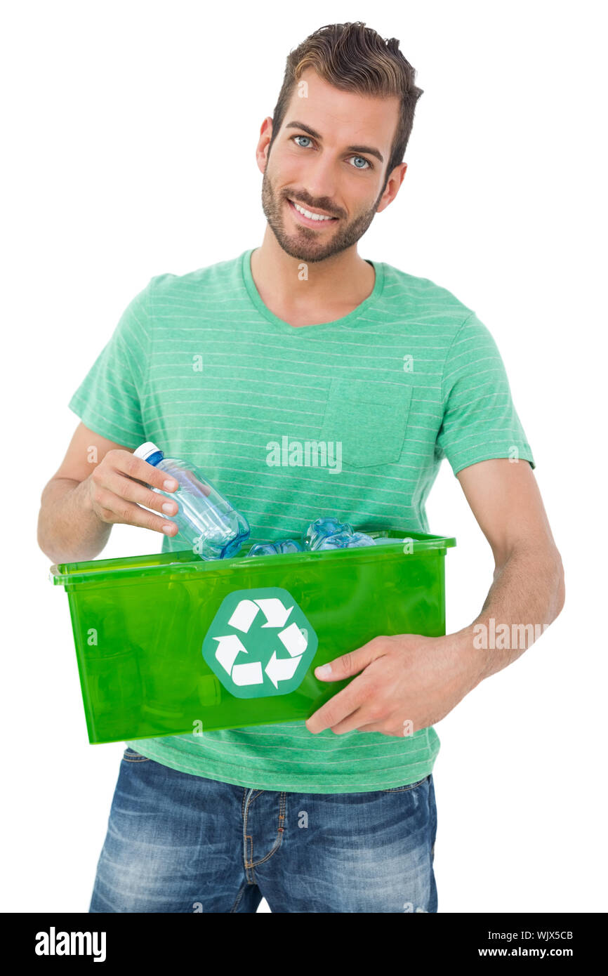 Portrait of a smiling young man carrying recycle container over white ...