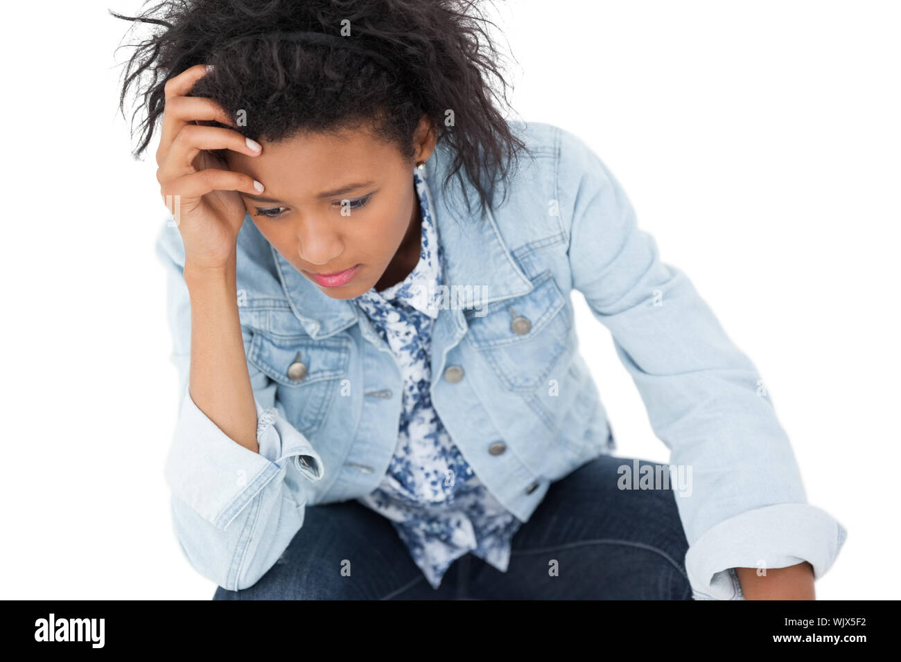 Close-up of a sad young woman sitting over white background Stock Photo ...