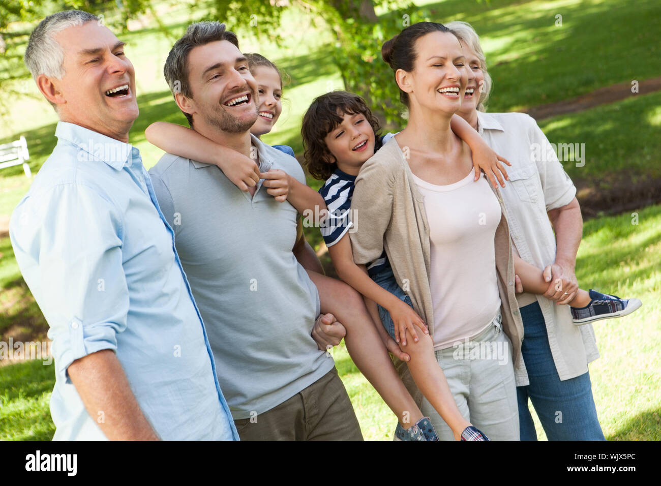 Side view of a cheerful extended family standing at the park Stock ...