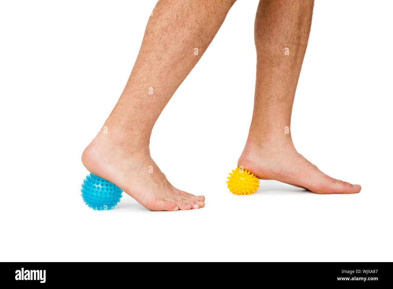 Close-up low section of man standing over stress balls against white ...
