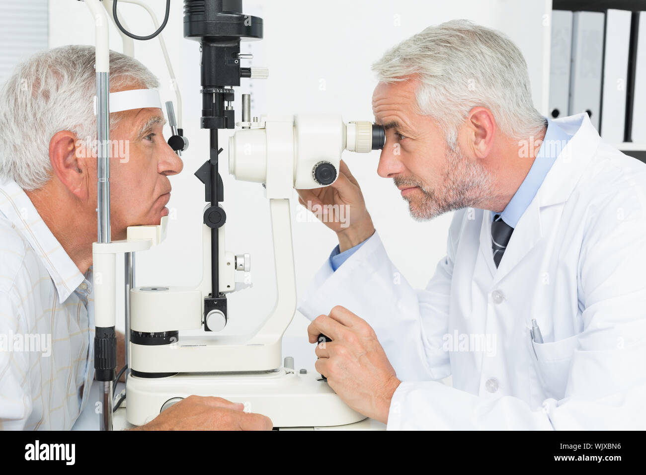 Side view of an optometrist doing sight testing for senior patient ...
