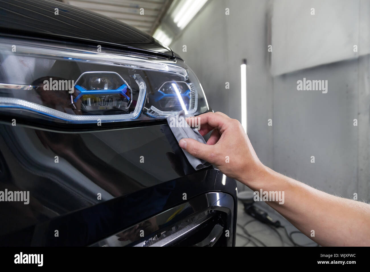 The process of applying a nano-ceramic coating on the car's bumper by a ...