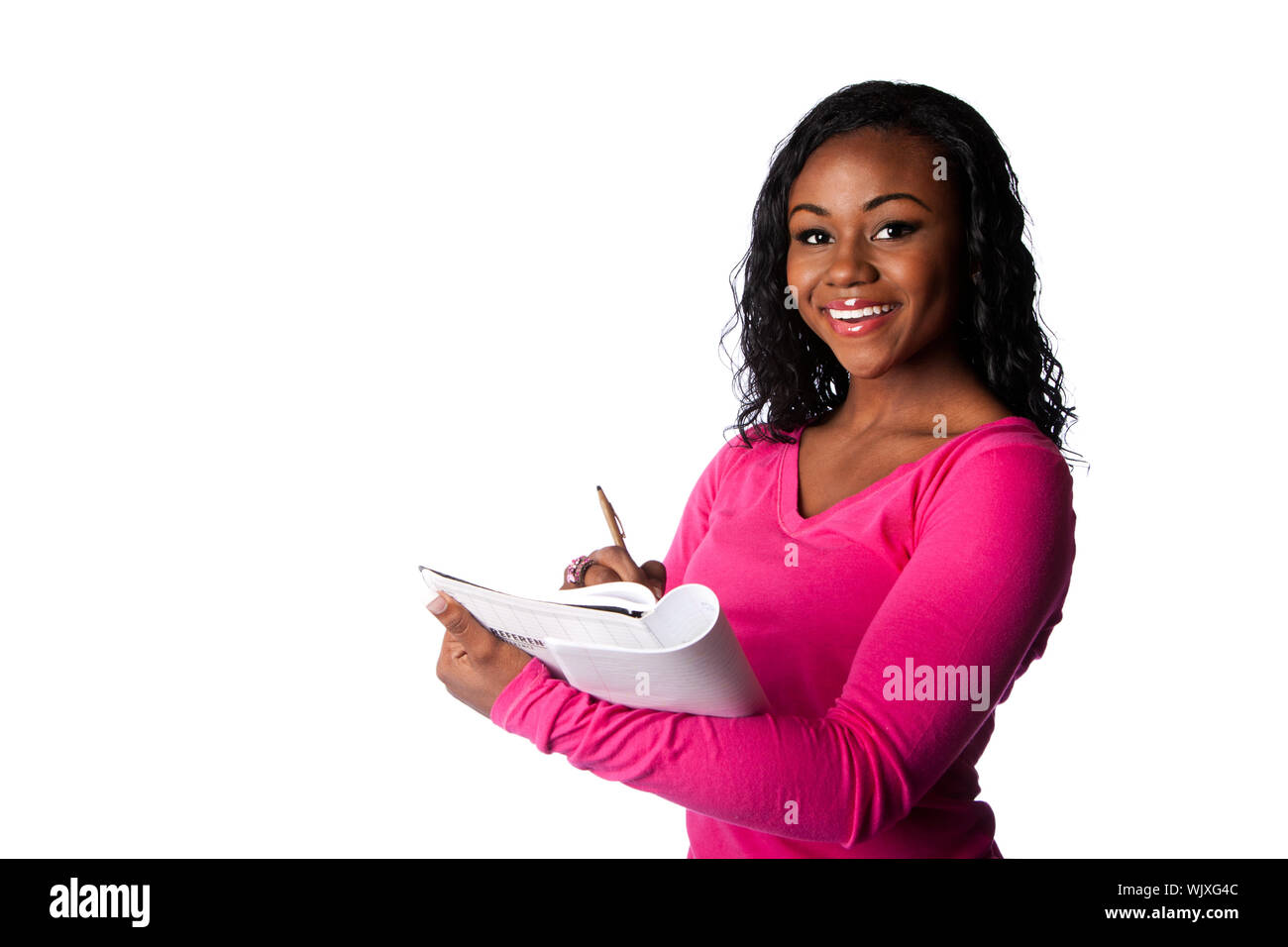 Beautiful happy smart college student smiling and writing in notebook ...