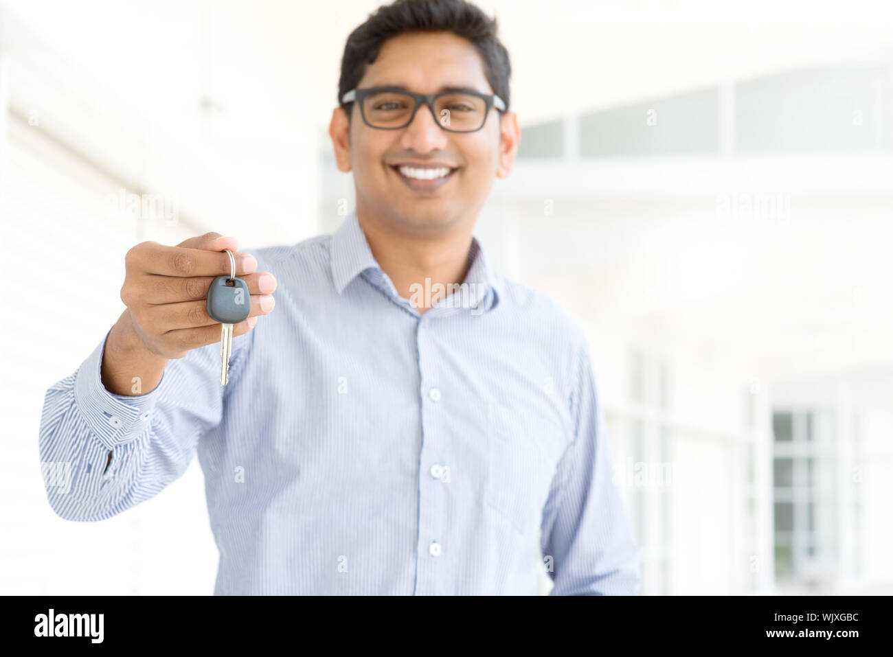 Young Asian Indian estate agent or salesman showing a key, India male ...
