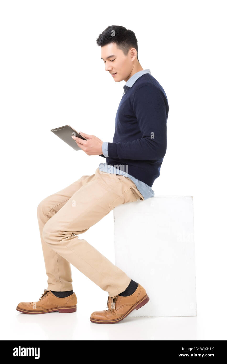 Handsome Asian guy sit and use pad, full length portrait isolated on ...