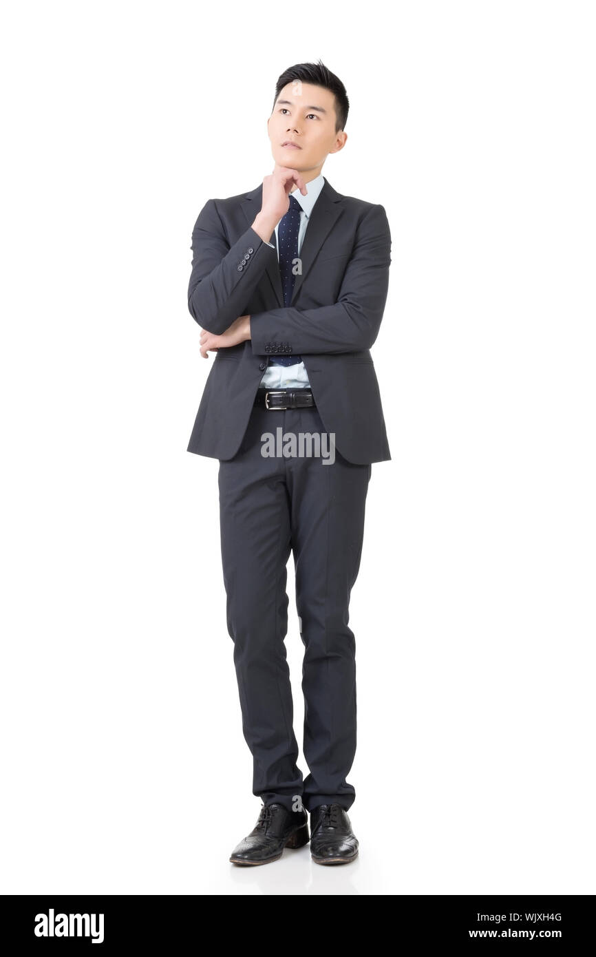 Confused young business man standing and thinking, full length portrait ...